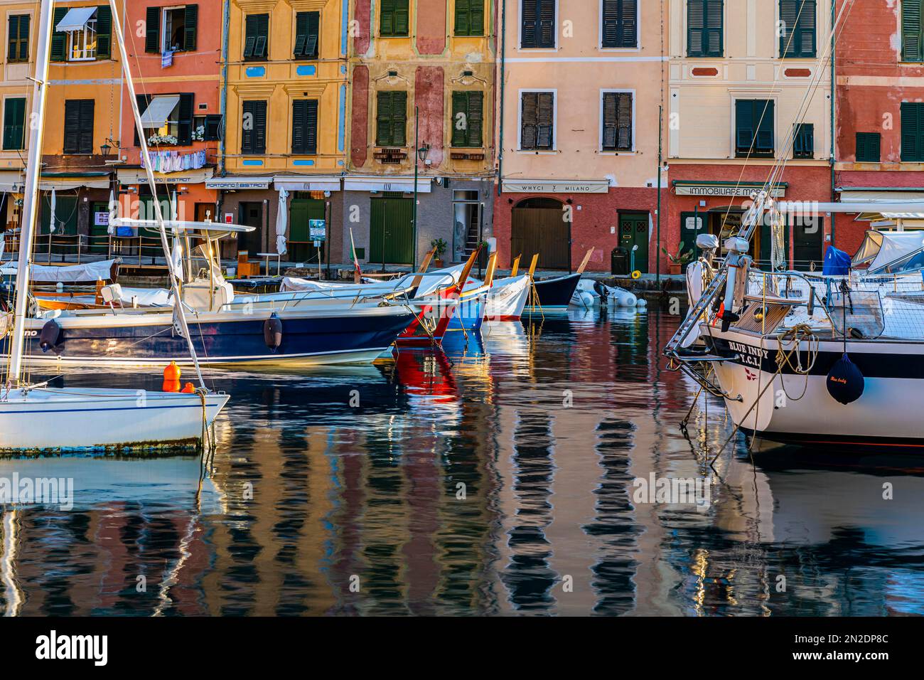 Pastel-coloured house facades are reflected in the harbour of Portofino ...