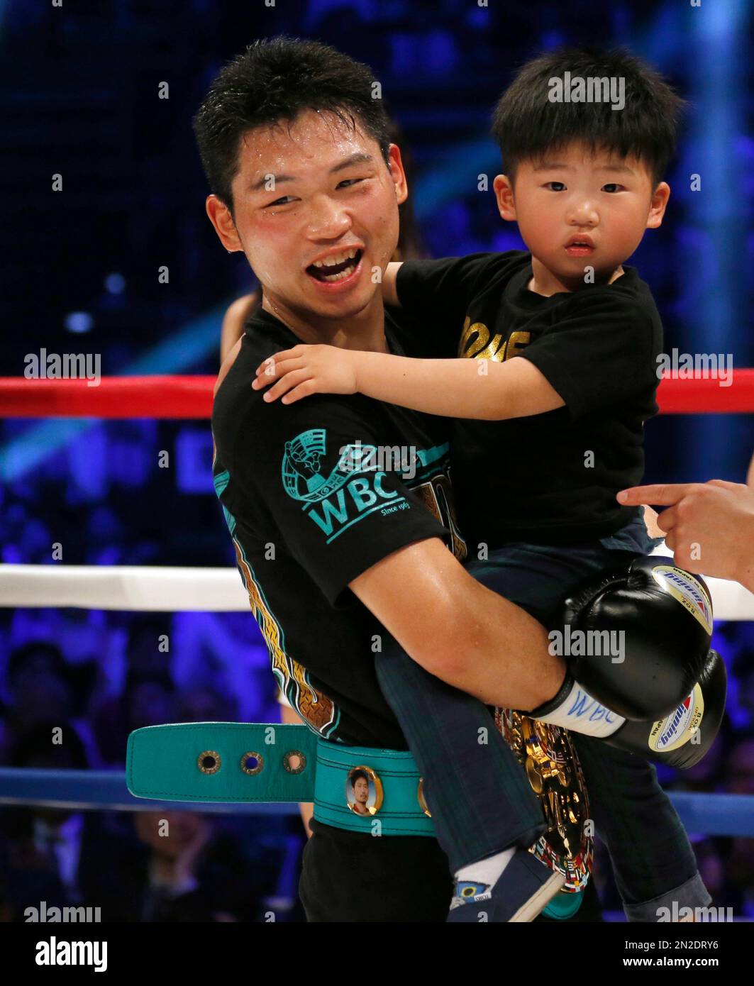 Japanese champion Takashi Miura holds his son Takeharu after knocking ...