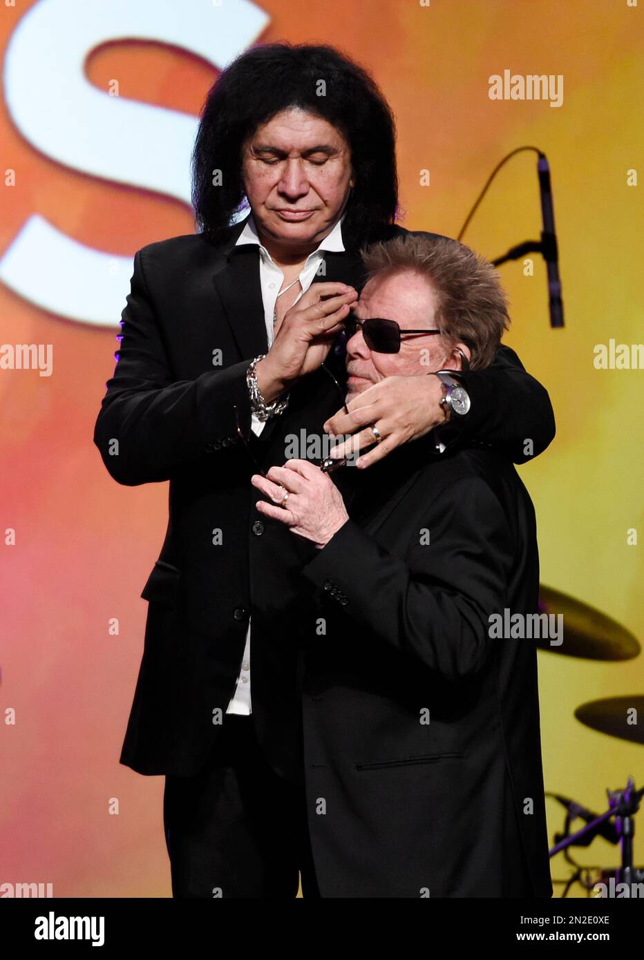 Gene Simmons, left, of the rock band KISS puts his sunglasses on the ...