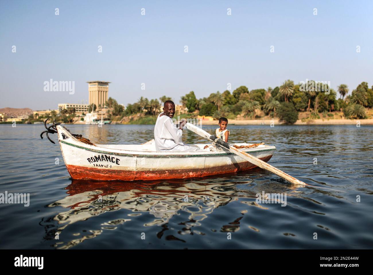 A fisherman and his son row their boat in the Nile River in Aswan ...