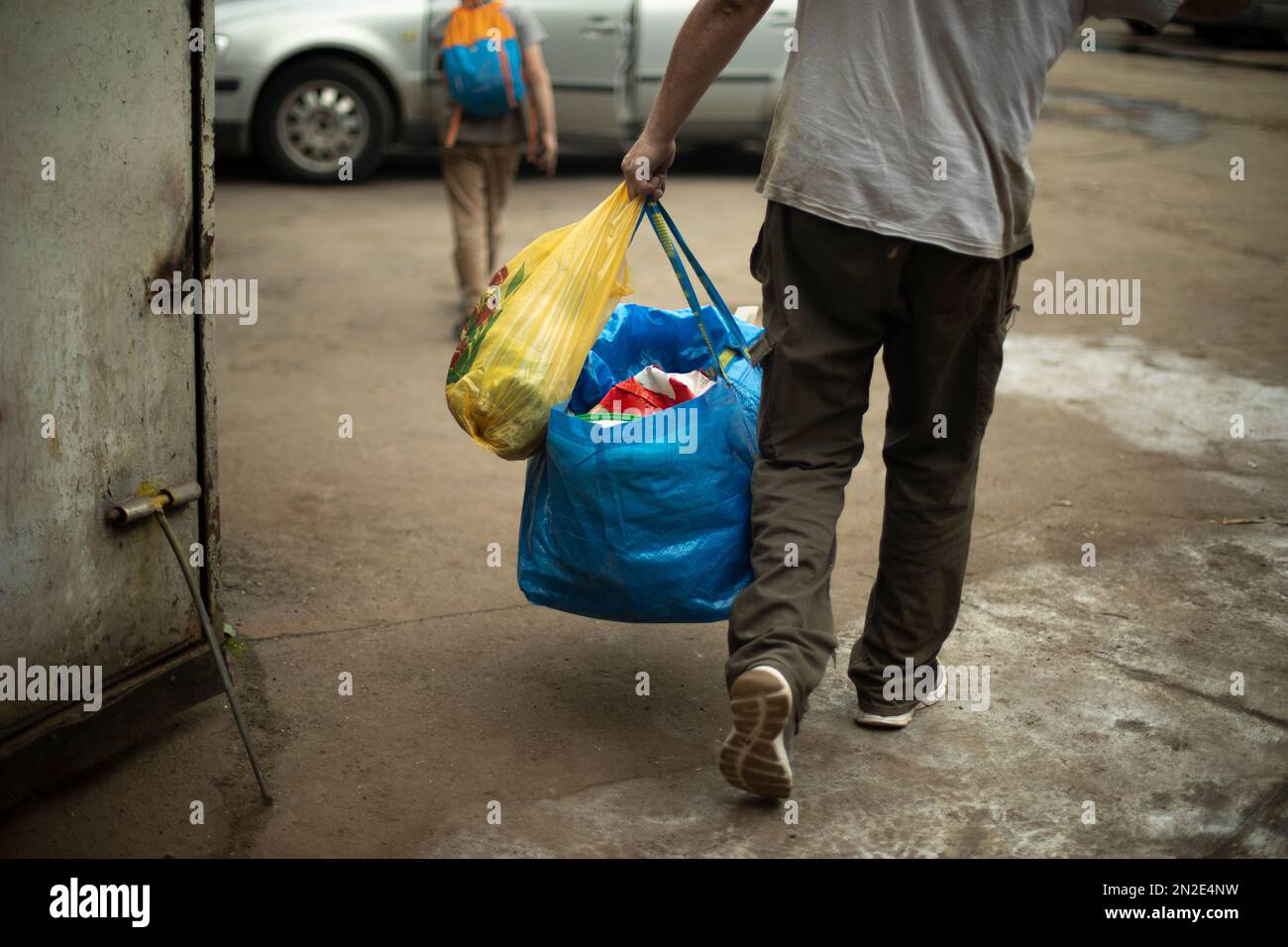 Man carrying blue bag. Moving with things. Guy dragging things. Person ...