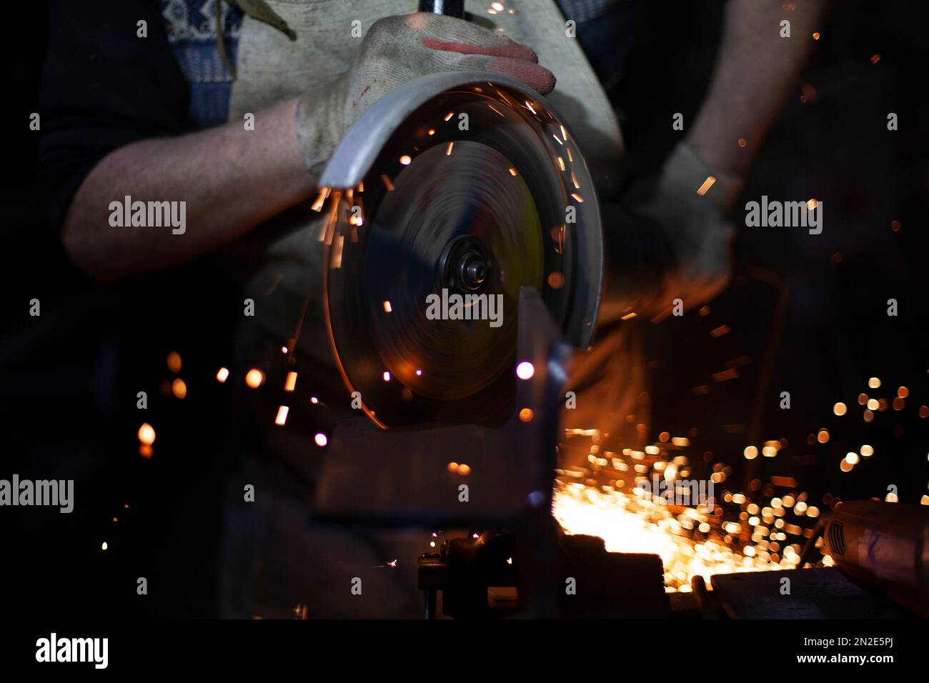 Metal sawing. Work on steel. Production details. Man cuts steel bar ...