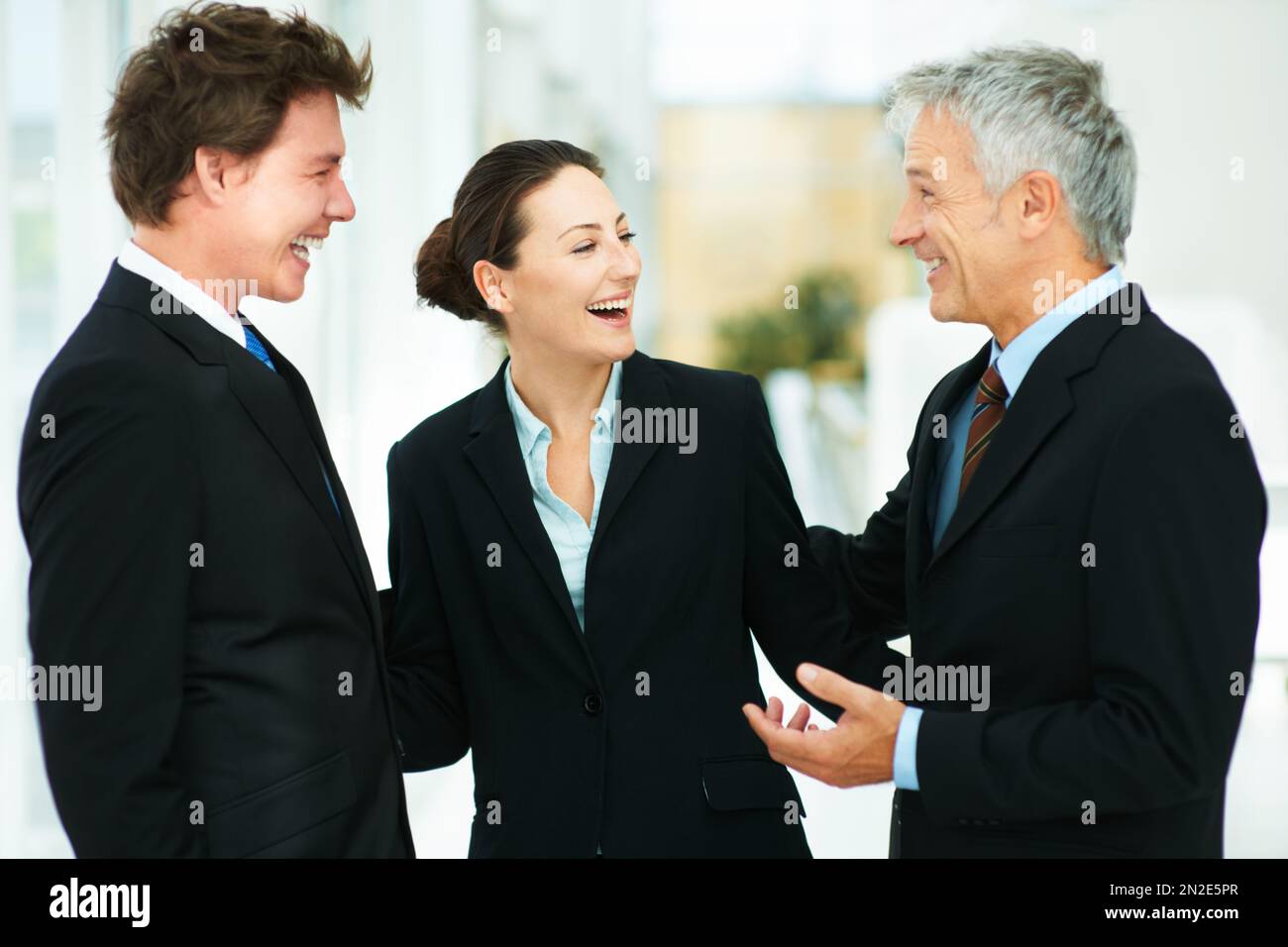 Getting along with my colleagues. a group of businesspeople laughing ...