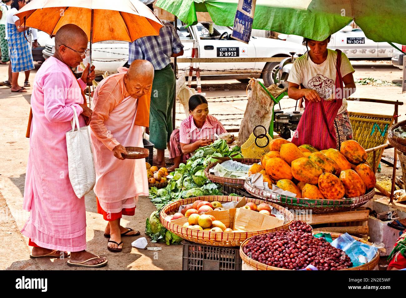 Female monks with begging bowl, Thiri Mingaleay vegetable market ...