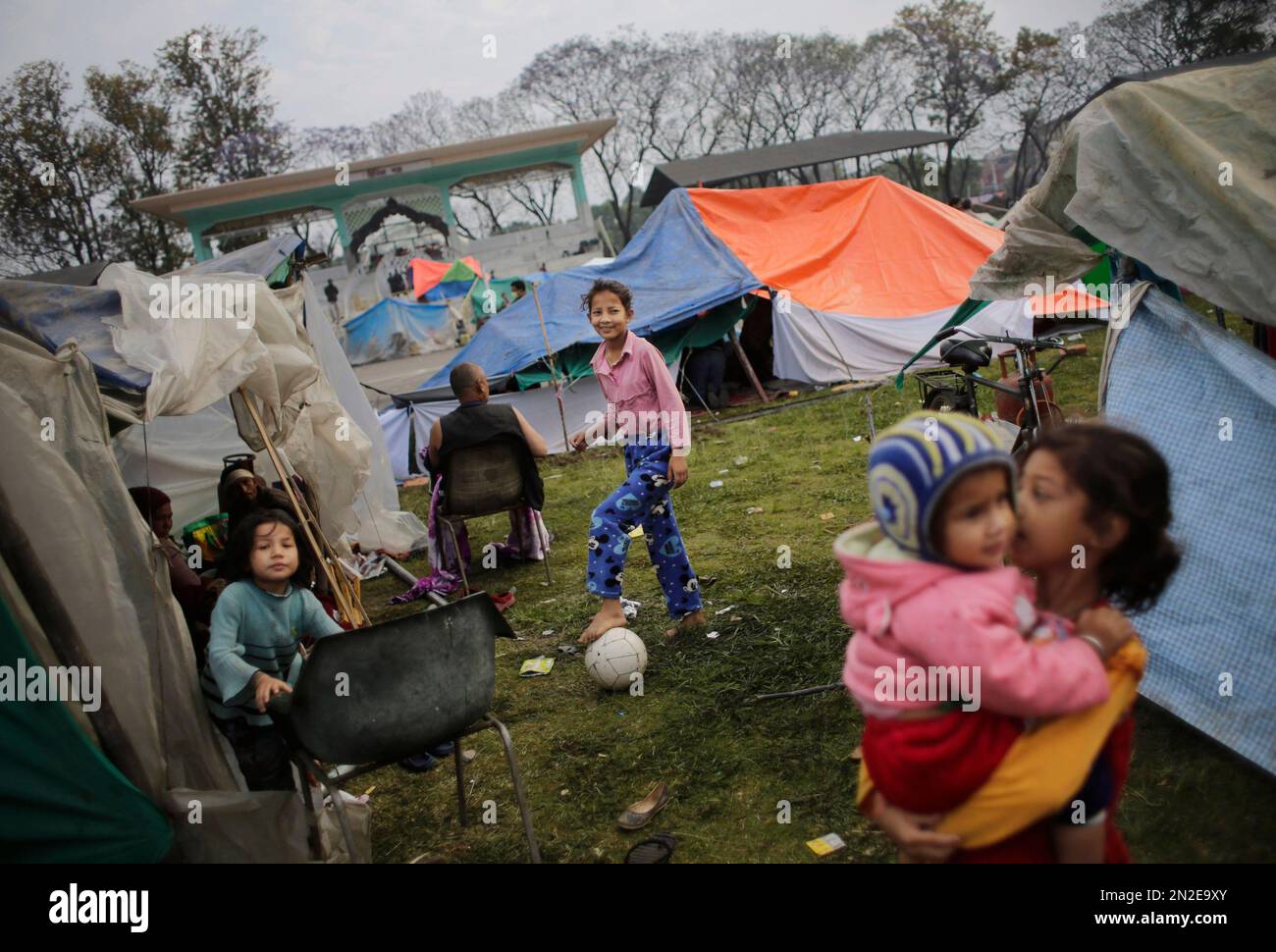 Survivors of Saturday's earthquake play outside their tents at a ...