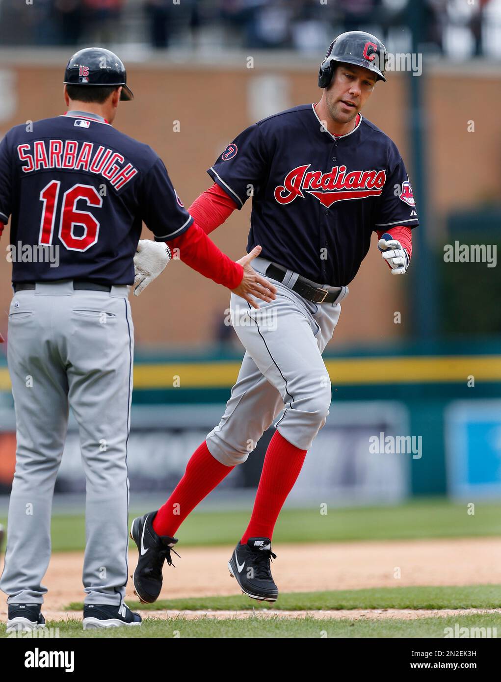 Cleveland Indians third base coach Mike Sarbaugh (16) congratulates ...