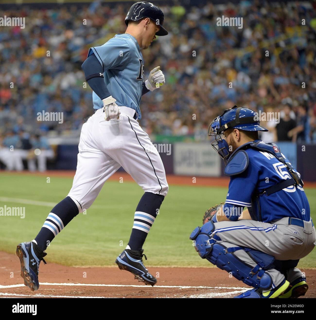 Tampa Bay Rays' Brandon Guyer, left, crosses home plate in front of ...