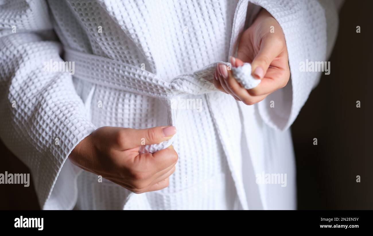 Female hands tying white bath robe closeup Stock Photo - Alamy