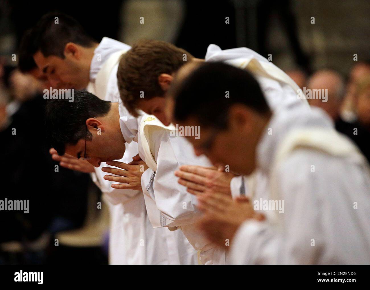 Nineteen new priests bow during a ceremony in which Pope Francis ...