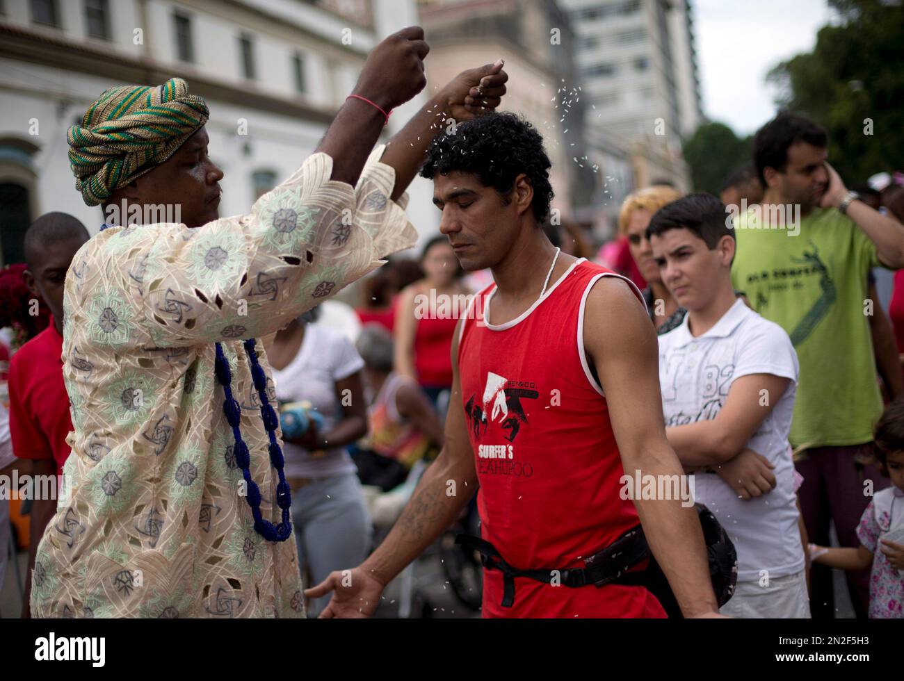 A candomble priest known as a Babalorisha sprinkles rice over a ...