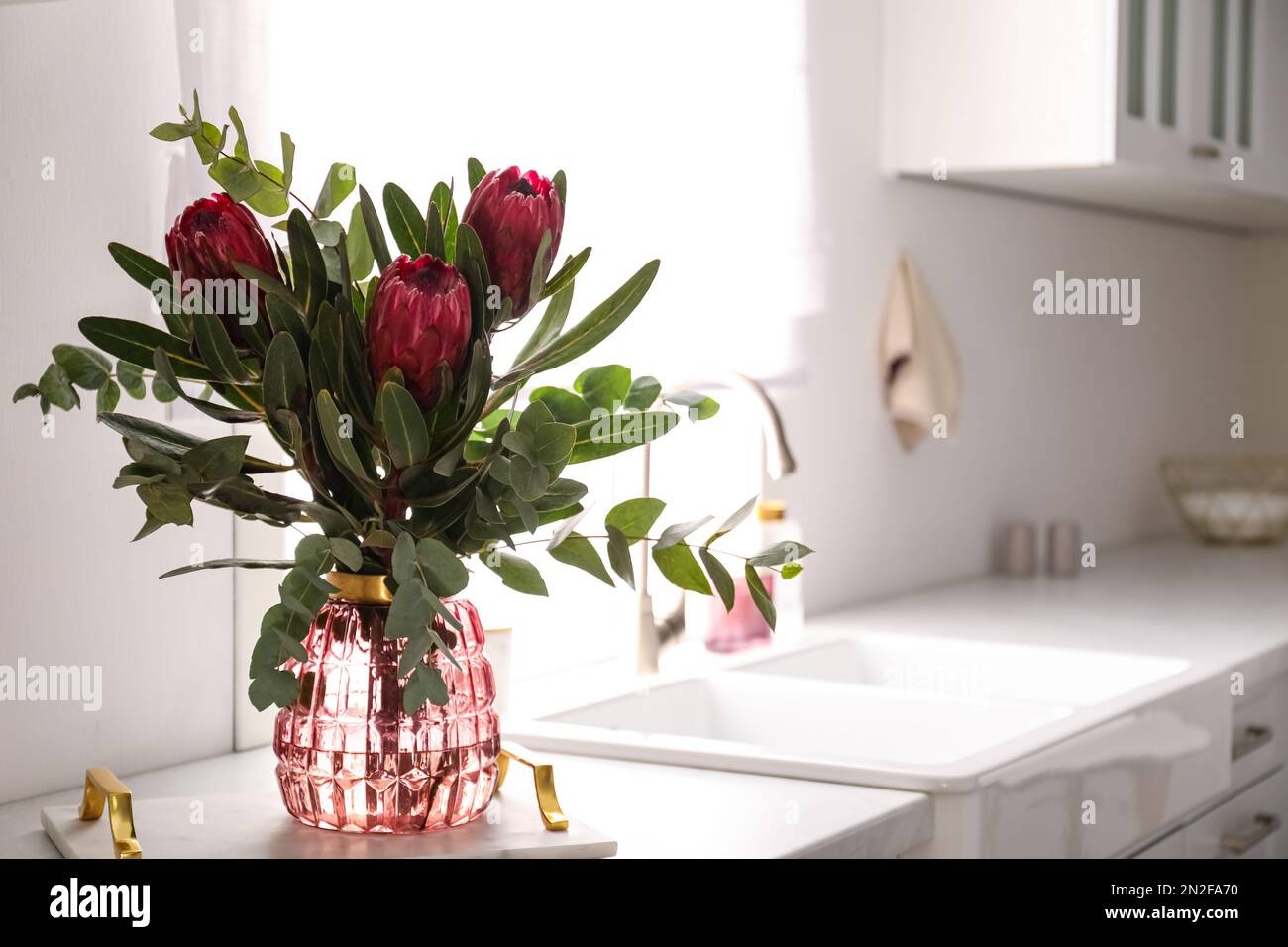 Bouquet with beautiful protea flowers on countertop in kitchen, space ...