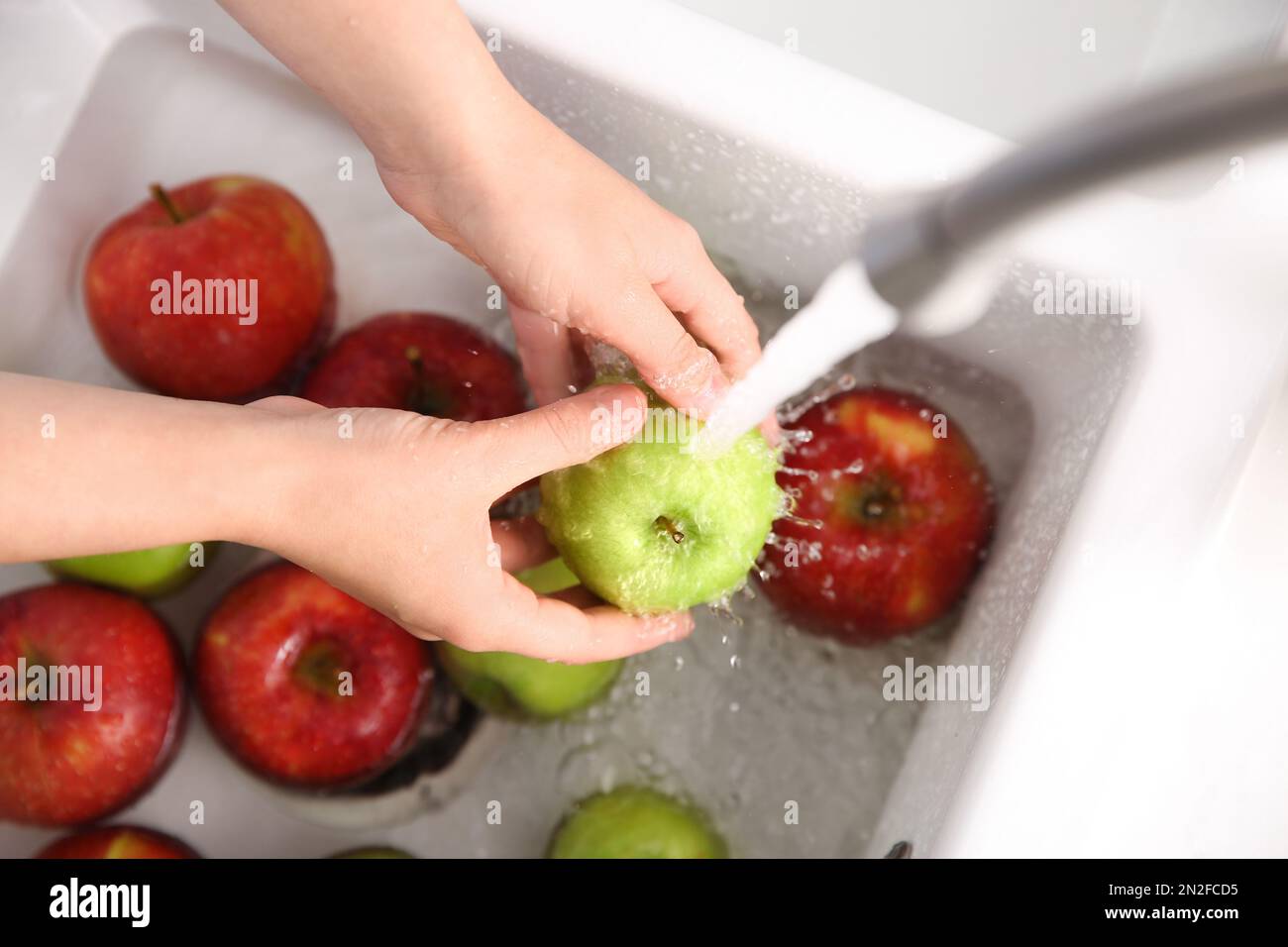 Woman washing fresh apples in kitchen sink, top view Stock Photo - Alamy