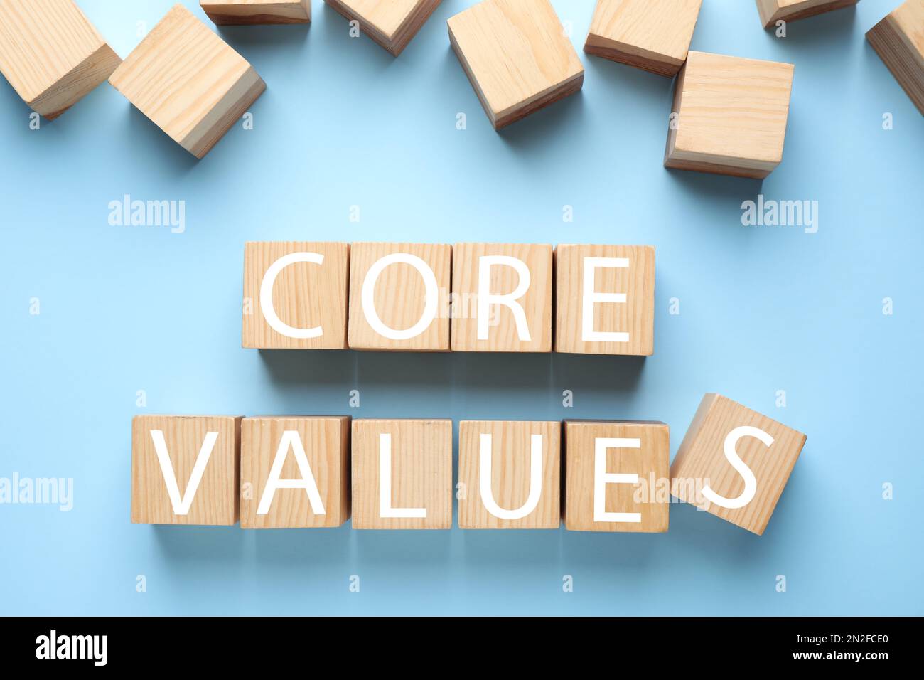 Wooden cubes with phrase CORE VALUES on light blue background, flat lay ...