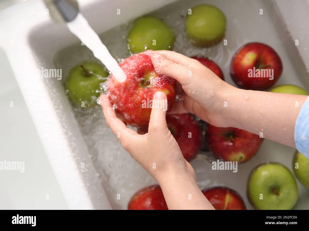 Hands washing green apples hi-res stock photography and images - Alamy