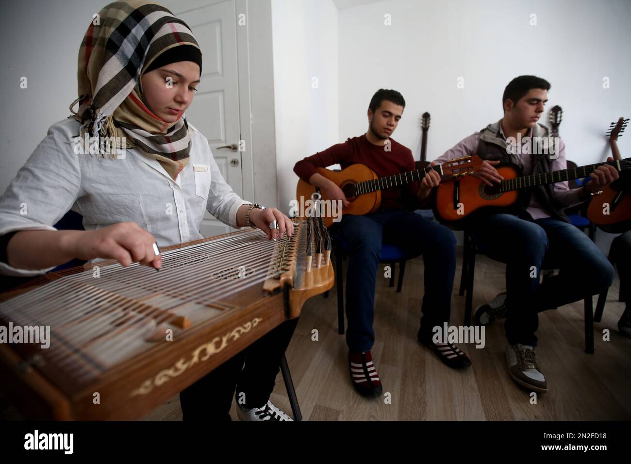 Syrian refugees play on their musical instruments as they attend a ...