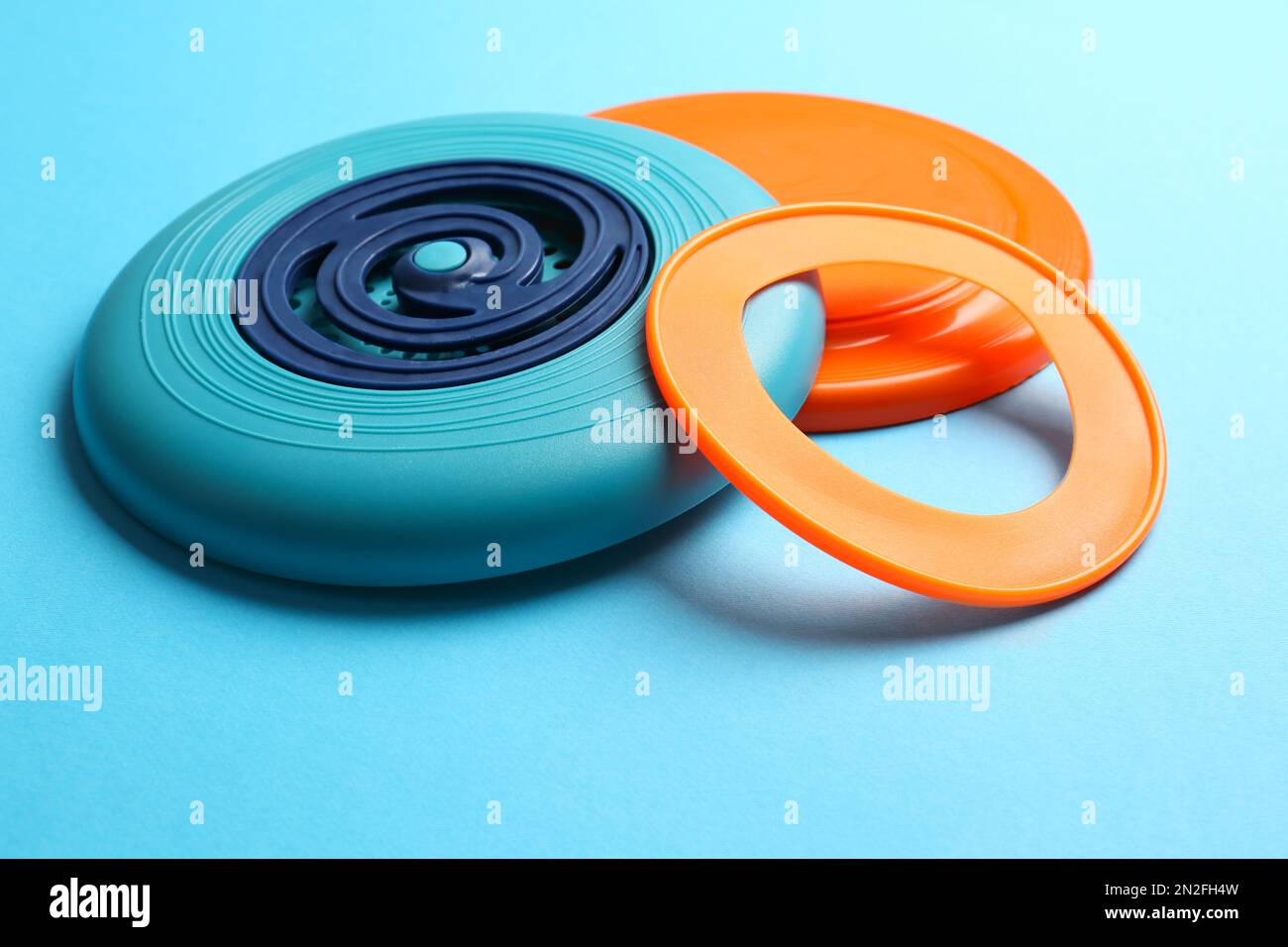 Plastic frisbee disks and ring on light blue background Stock Photo - Alamy