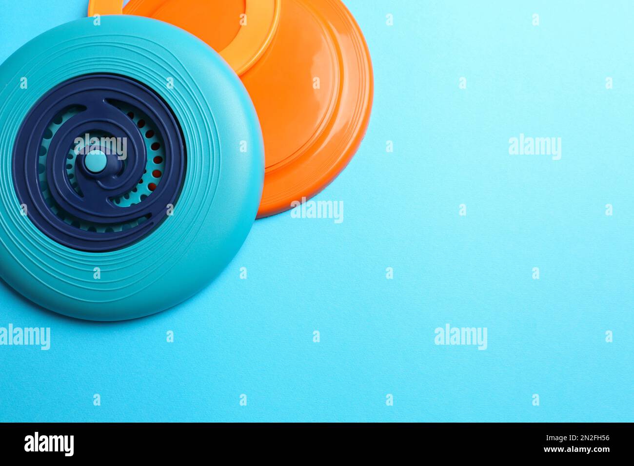 Plastic frisbee disks and ring on light blue background, flat lay ...