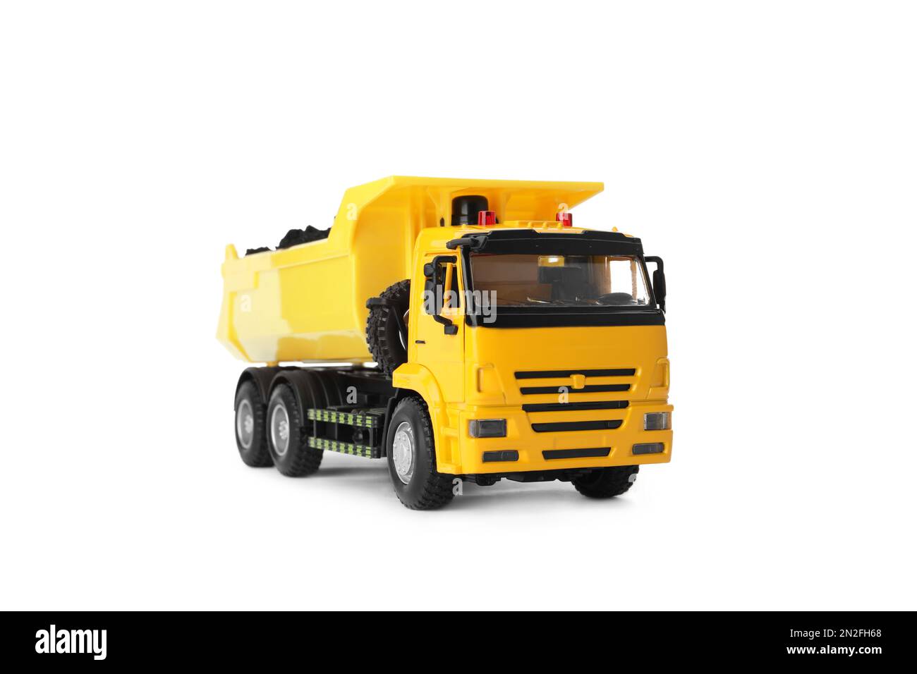 Yellow toy tipper truck with coal isolated on white Stock Photo - Alamy