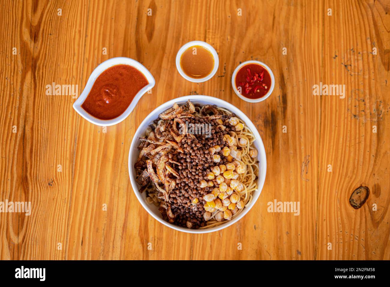 A top view of kushari plate Egyptian national dish and different sauces ...