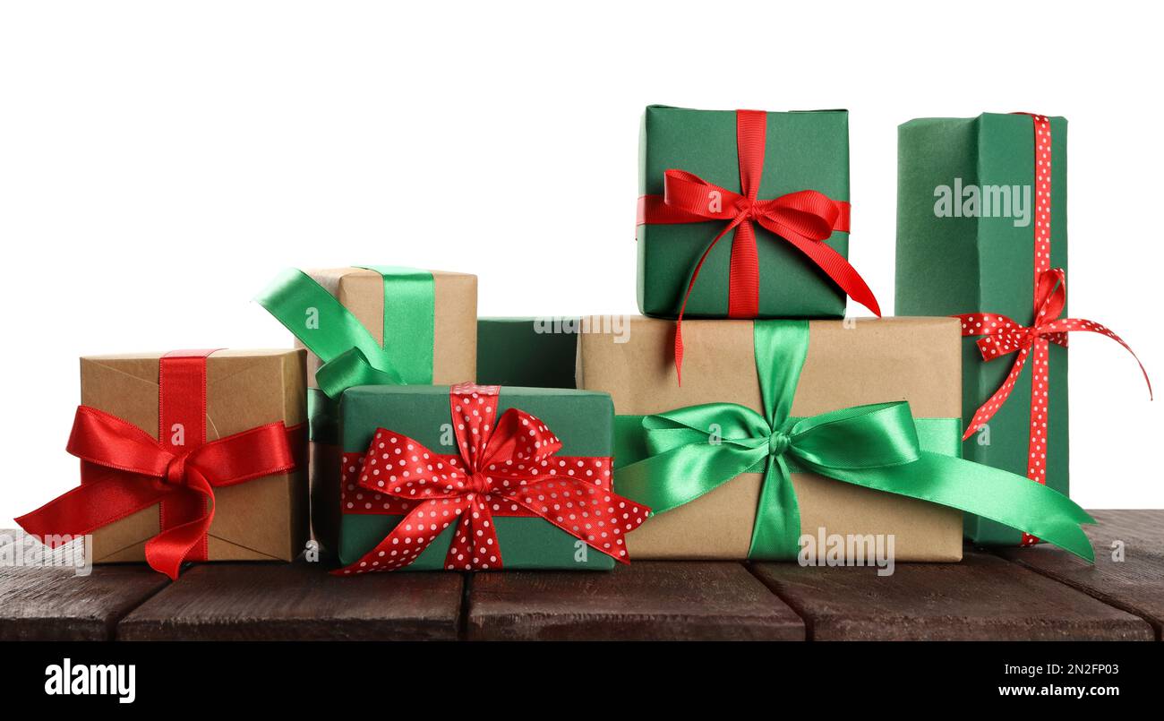 Many different Christmas gifts on wooden table against white background ...
