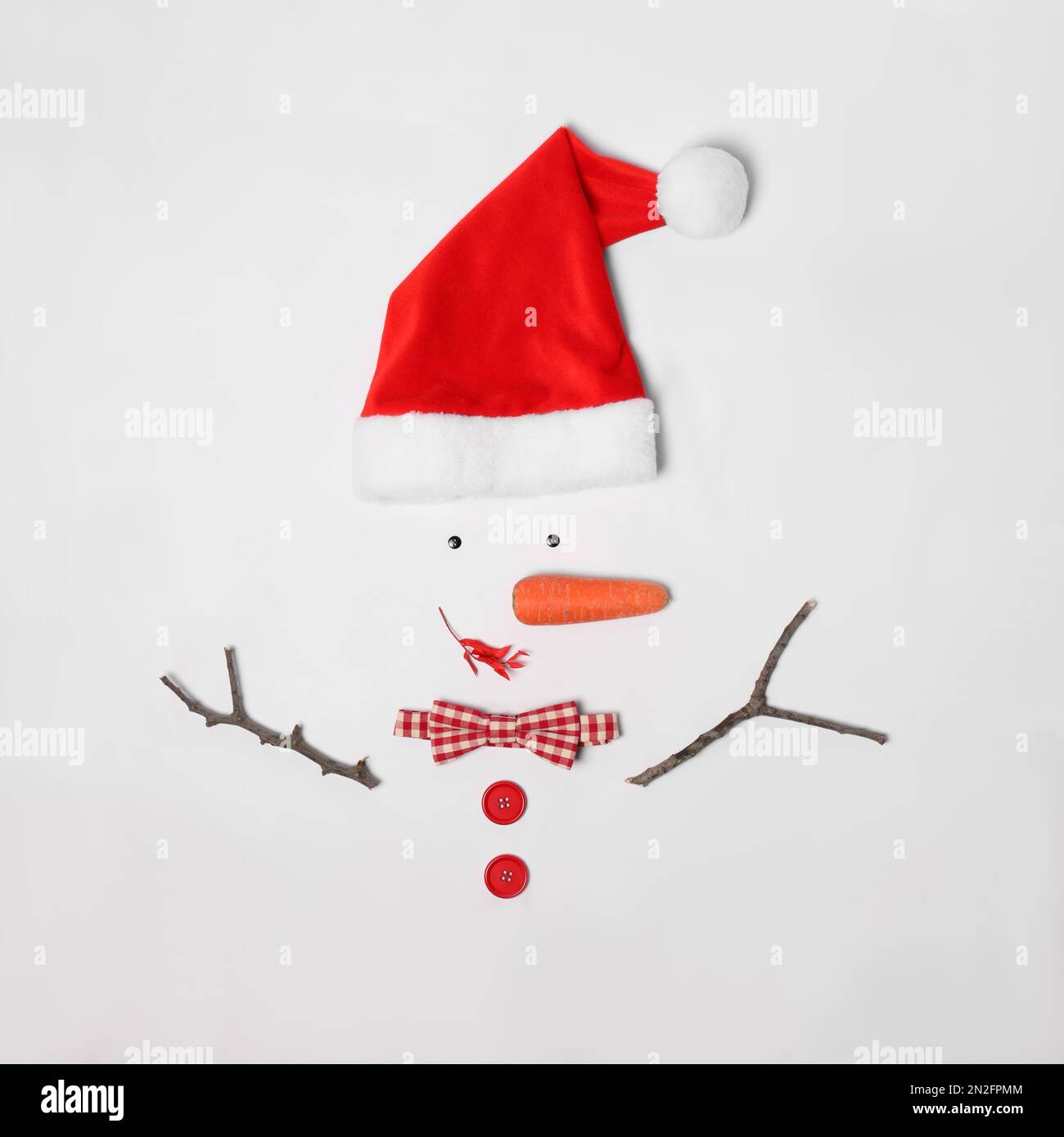 Creative snowman shape made of Santa hat and different items on white ...