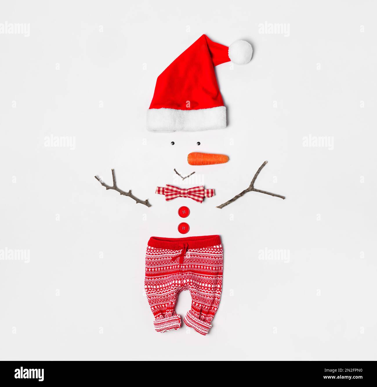 Creative snowman shape made of Santa hat and different items on white ...