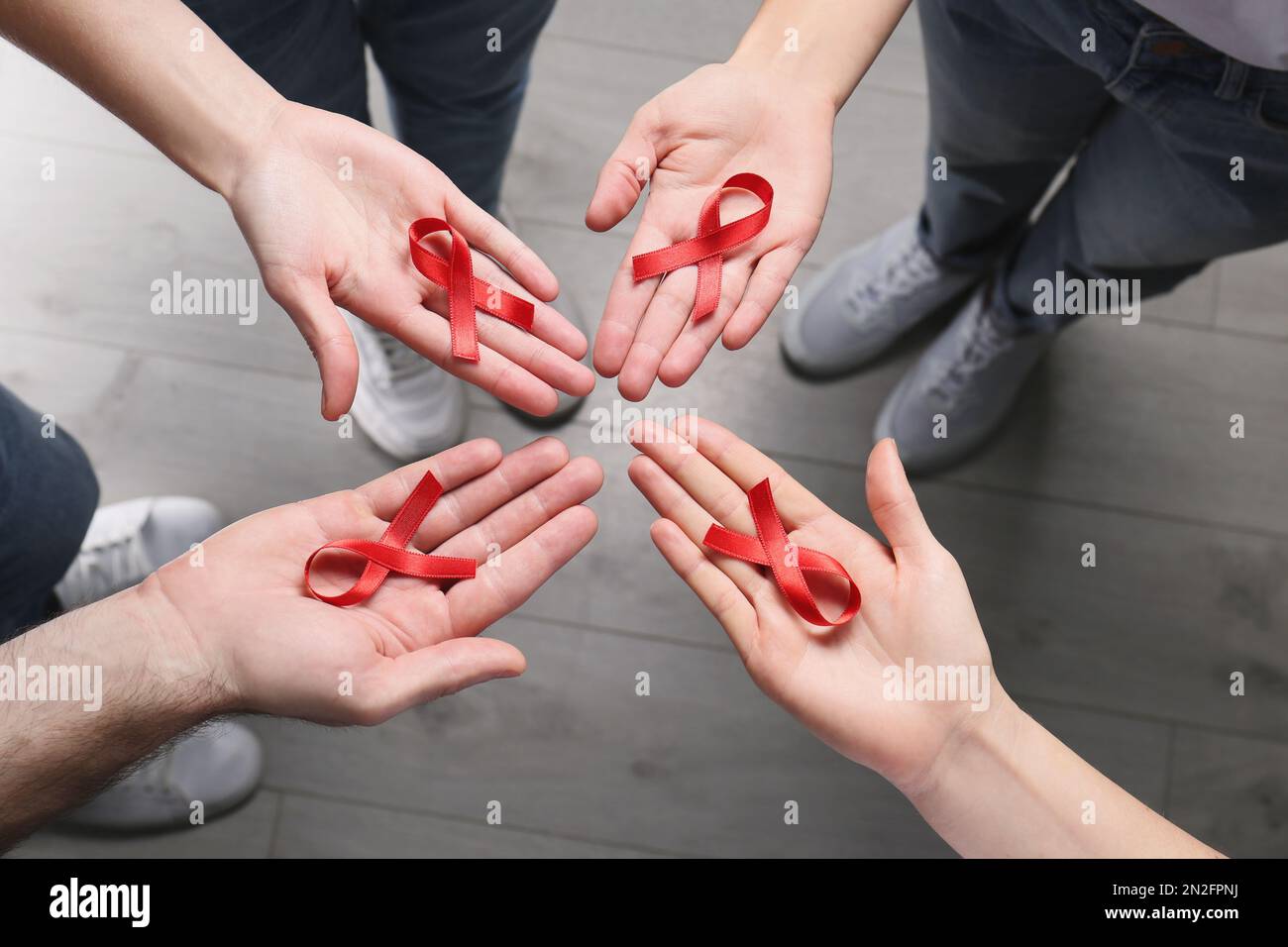 Group of people holding red awareness ribbons indoors, above view ...