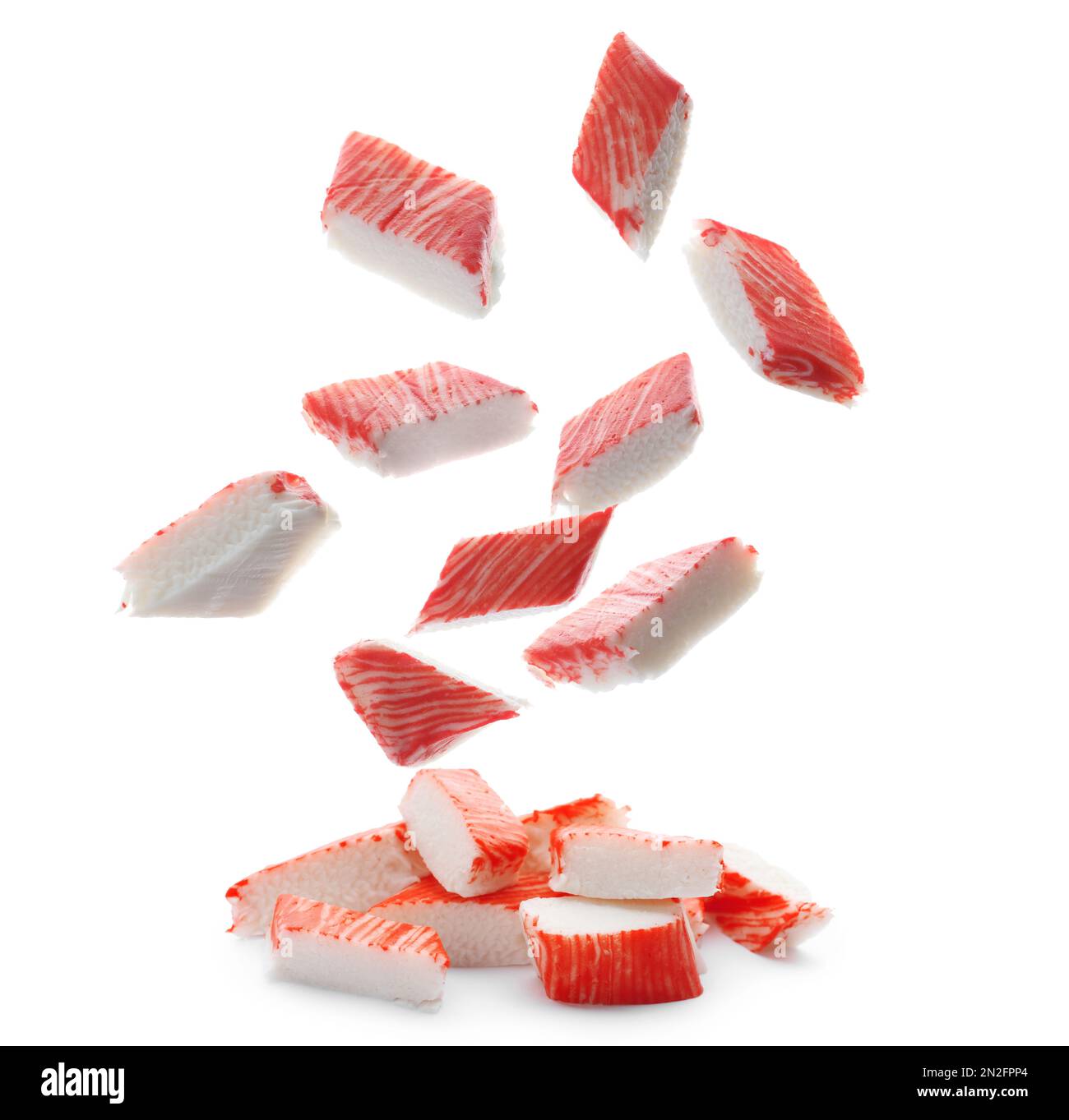 Cut fresh crab sticks falling on white background Stock Photo - Alamy