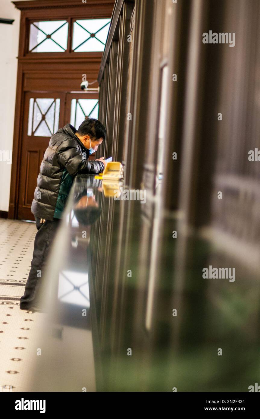 A man being served at the wooden counter of the Shanghai GPO Post ...