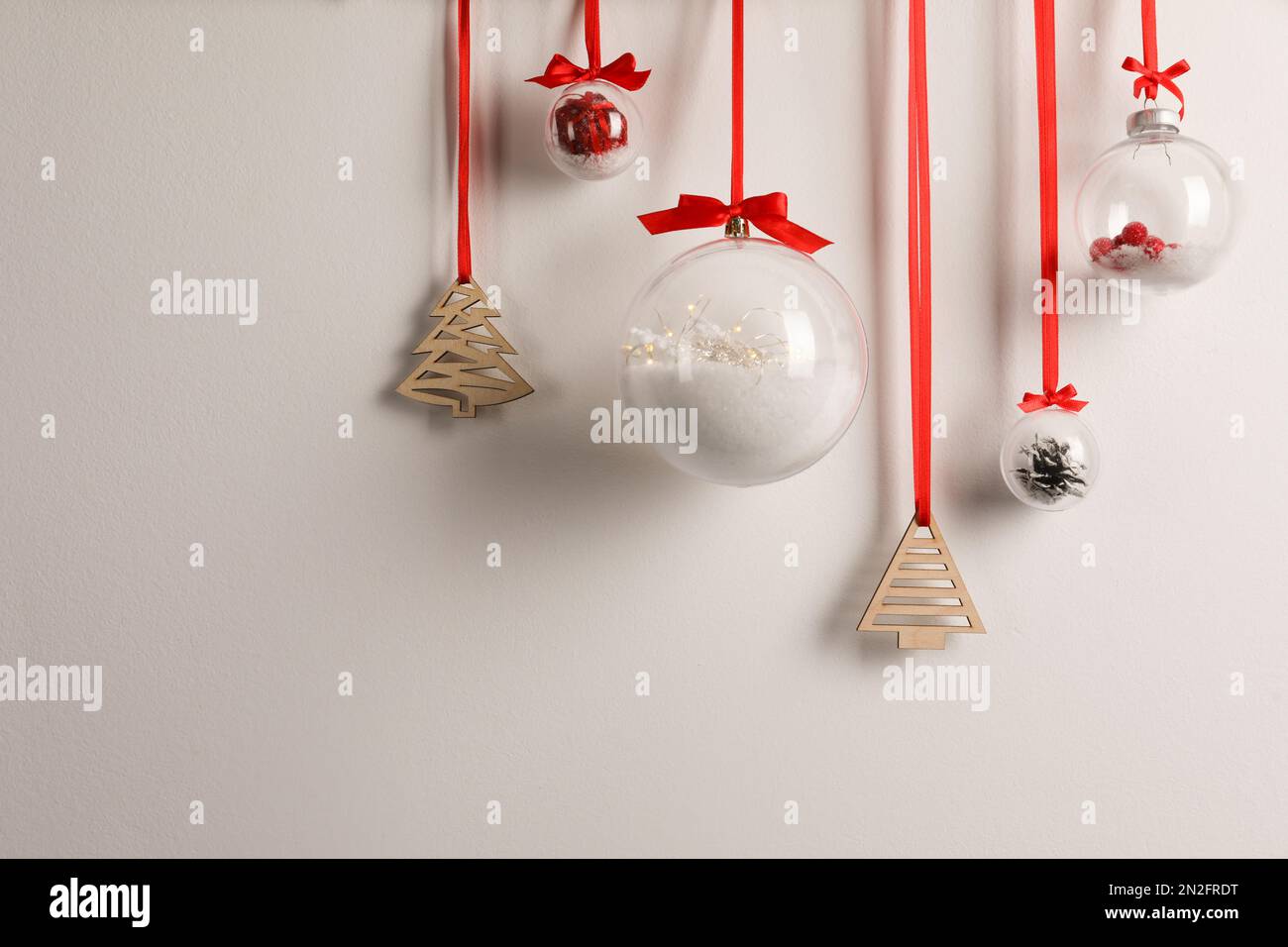 Decorative snow globes hanging on grey background Stock Photo - Alamy