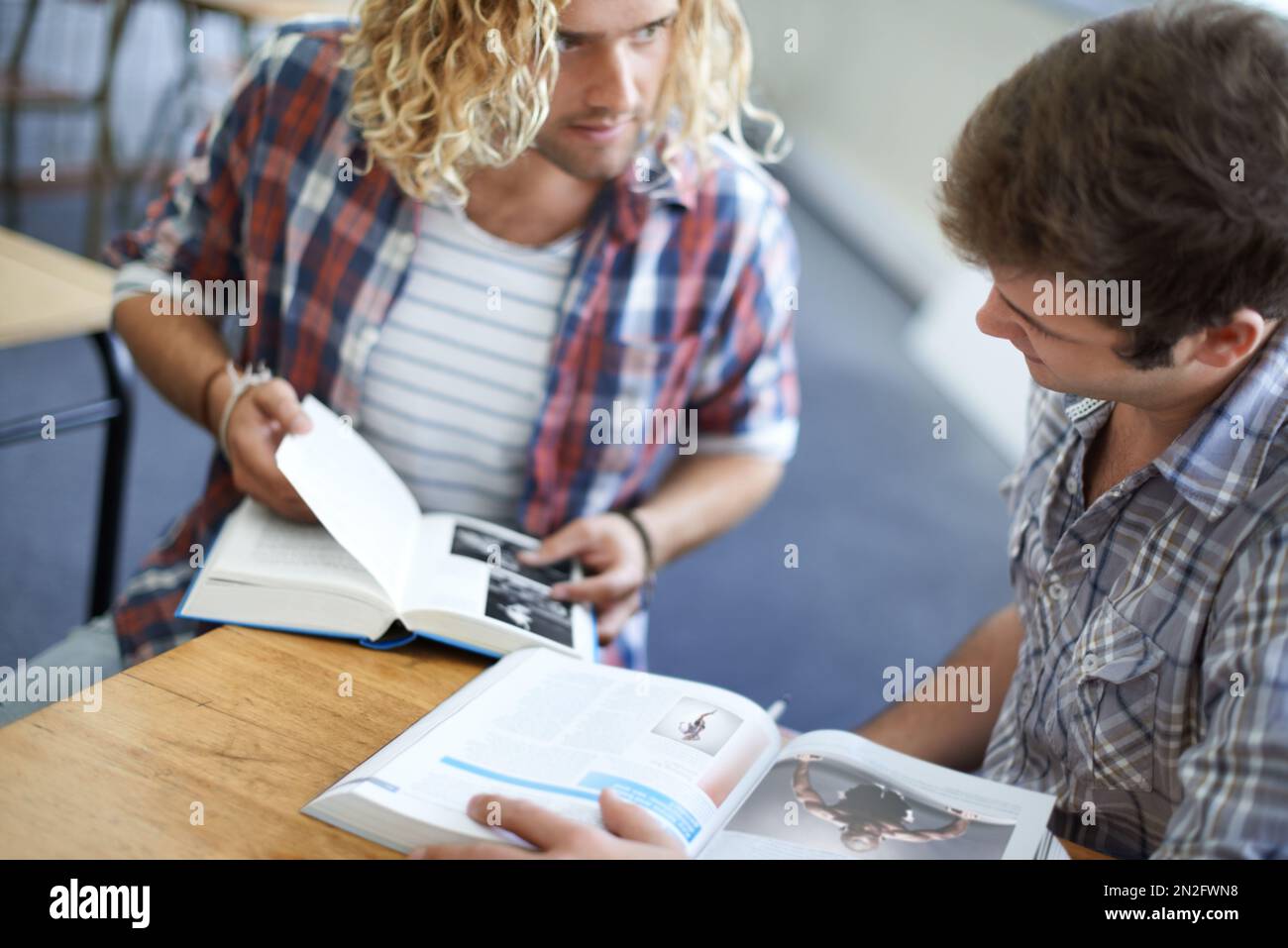 Comparing research. two male students studying together in class Stock ...