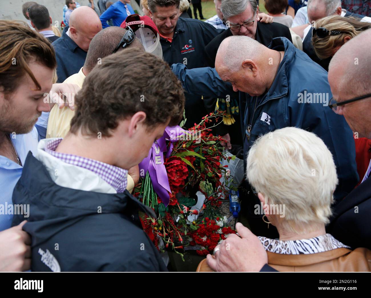 Retired police chaplain Jack Poe, upper right, leads a prayer for ...