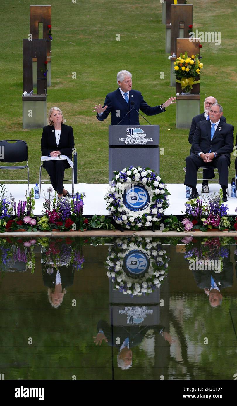 Former President Bill Clinton, center, is reflected in the reflecting ...