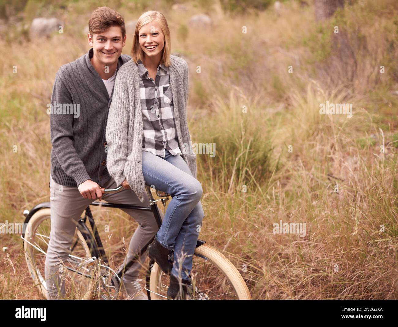 Romantic ride in Autumn. A young couple enjoying a bike ride outdoors ...