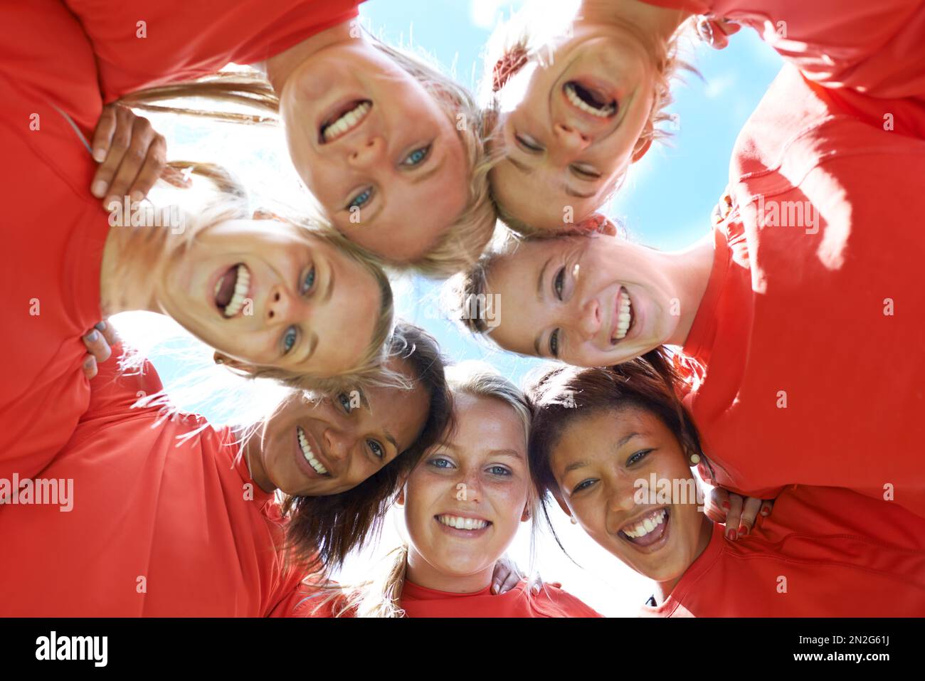 One for all. Low-angle portrait of an all-girls soccer team standing in ...