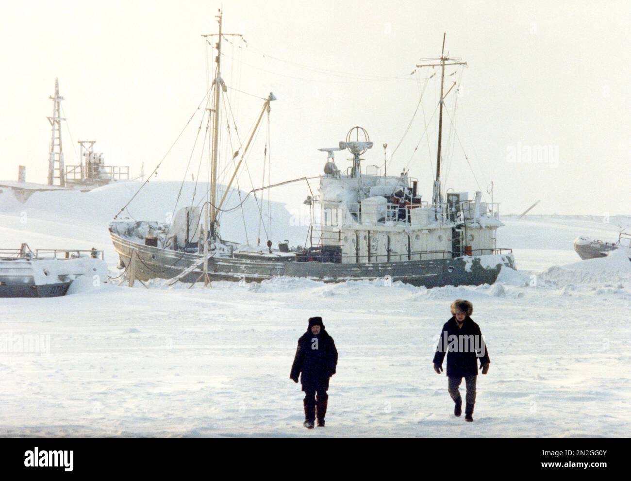 Two residents stroll across the frozen harbour of Dikson Island, Russia ...