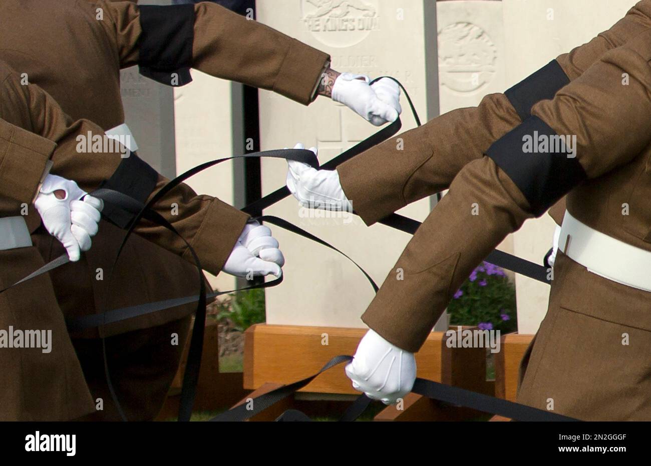Soldiers pull the straps from under the casket of a British World War I ...
