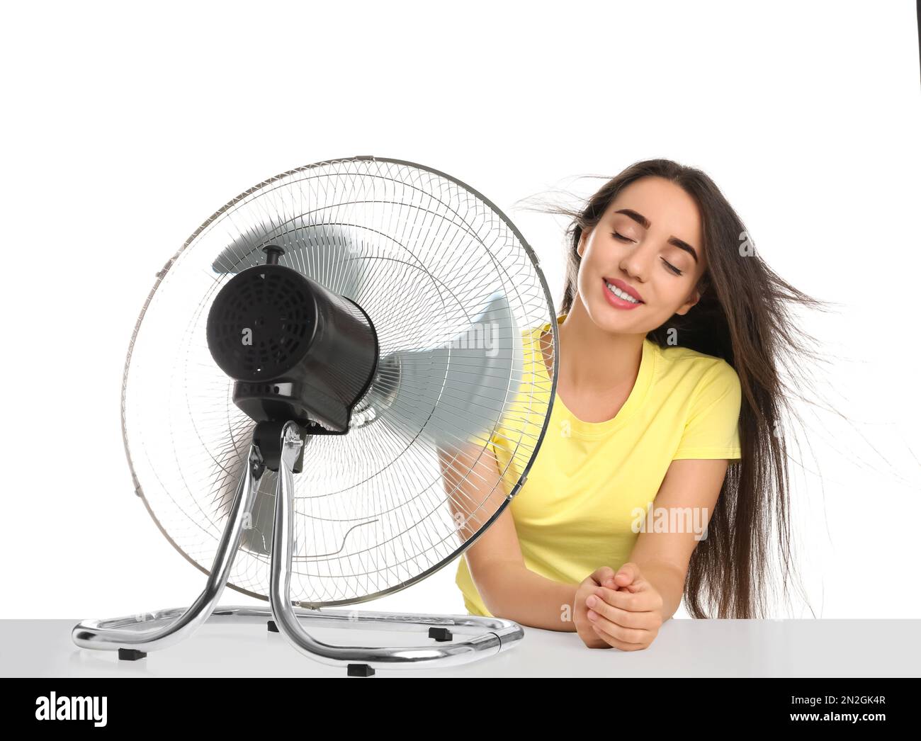 Woman enjoying air flow from fan on white background. Summer heat Stock ...