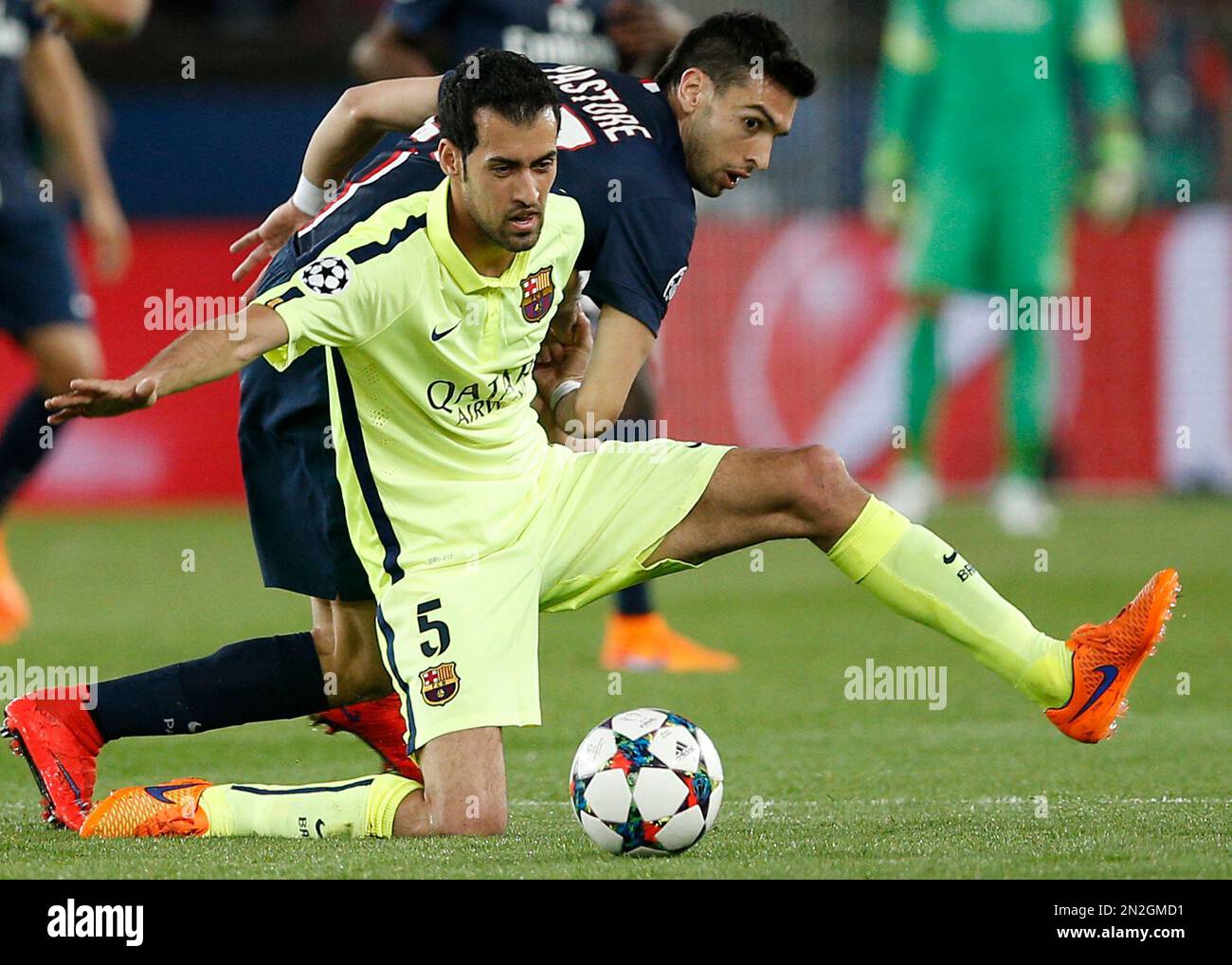 Barcelona's Sergio Busquets, front, shields the ball from PSG's Javier ...