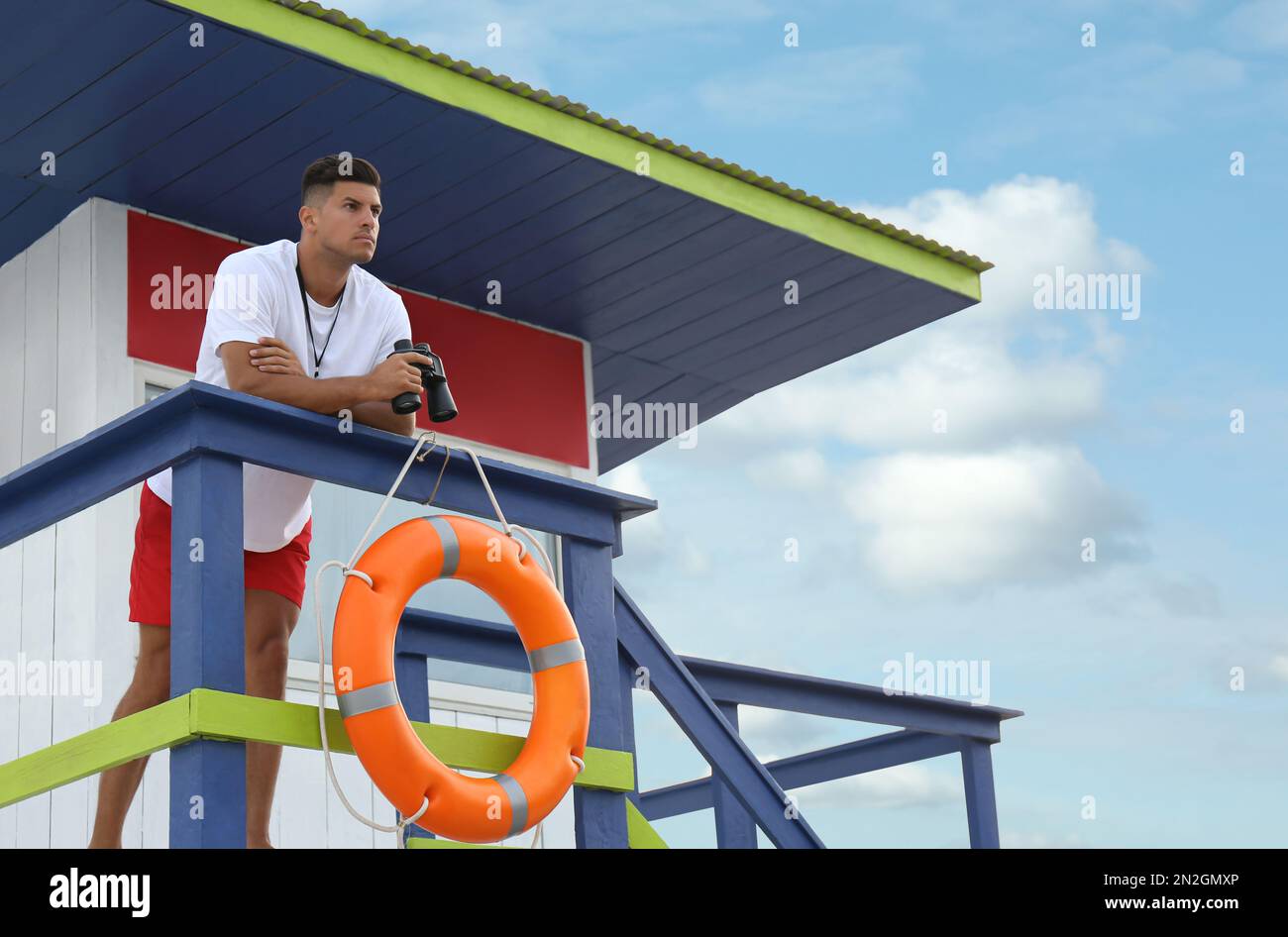 Male lifeguard with binocular on watch tower Stock Photo - Alamy