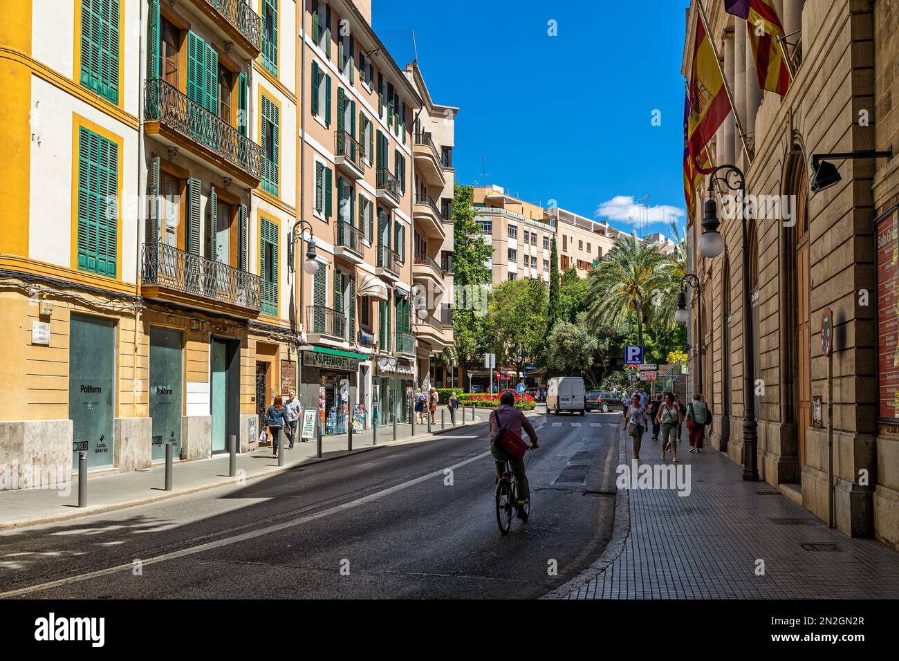 People walking on narrow urban street among colorful buildings in Palma ...