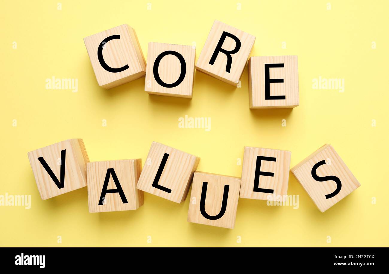 Wooden cubes with phrase CORE VALUES on yellow background, flat lay ...
