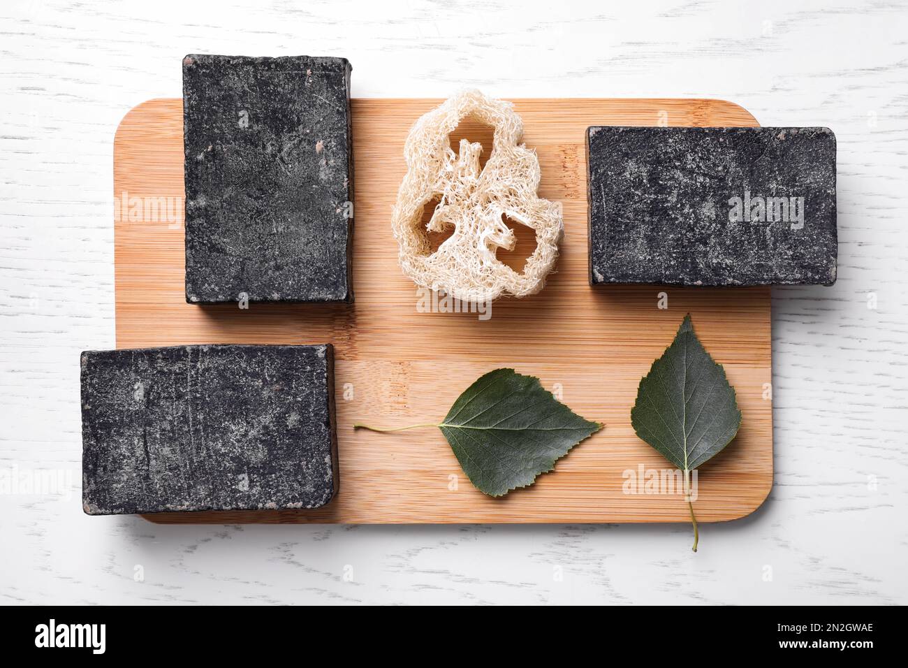Natural tar soap and loofah on white wooden table, top view Stock Photo ...