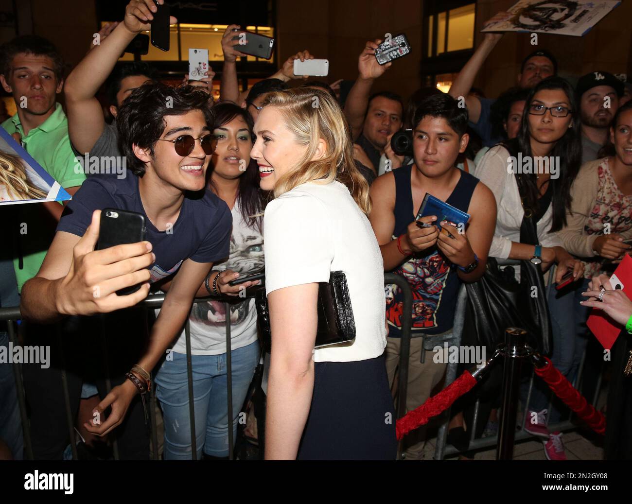 Elizabeth Olsen poses for a photo with a fan at the Los Angeles ...