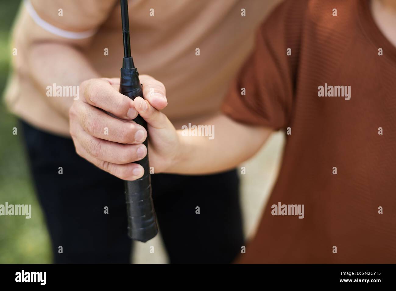 Grandfather explaining kid how to hold badminton racket Stock Photo - Alamy