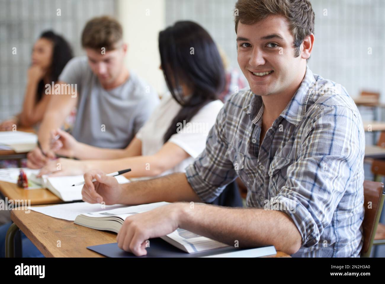 Aiming for an A. a group of young college students studying in class ...