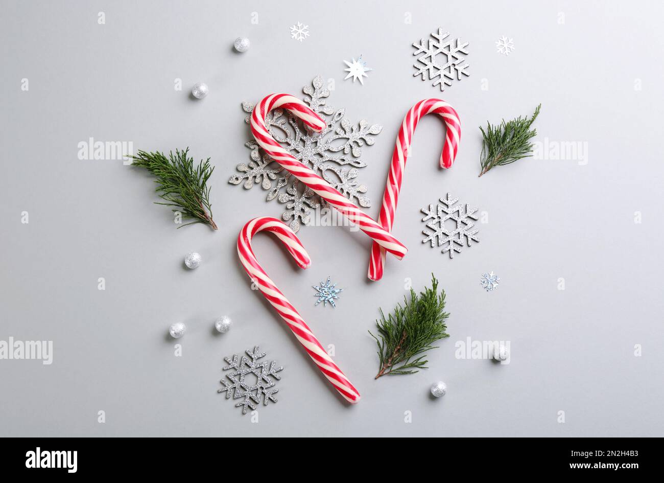 Flat lay composition with candy canes and Christmas decor on grey ...