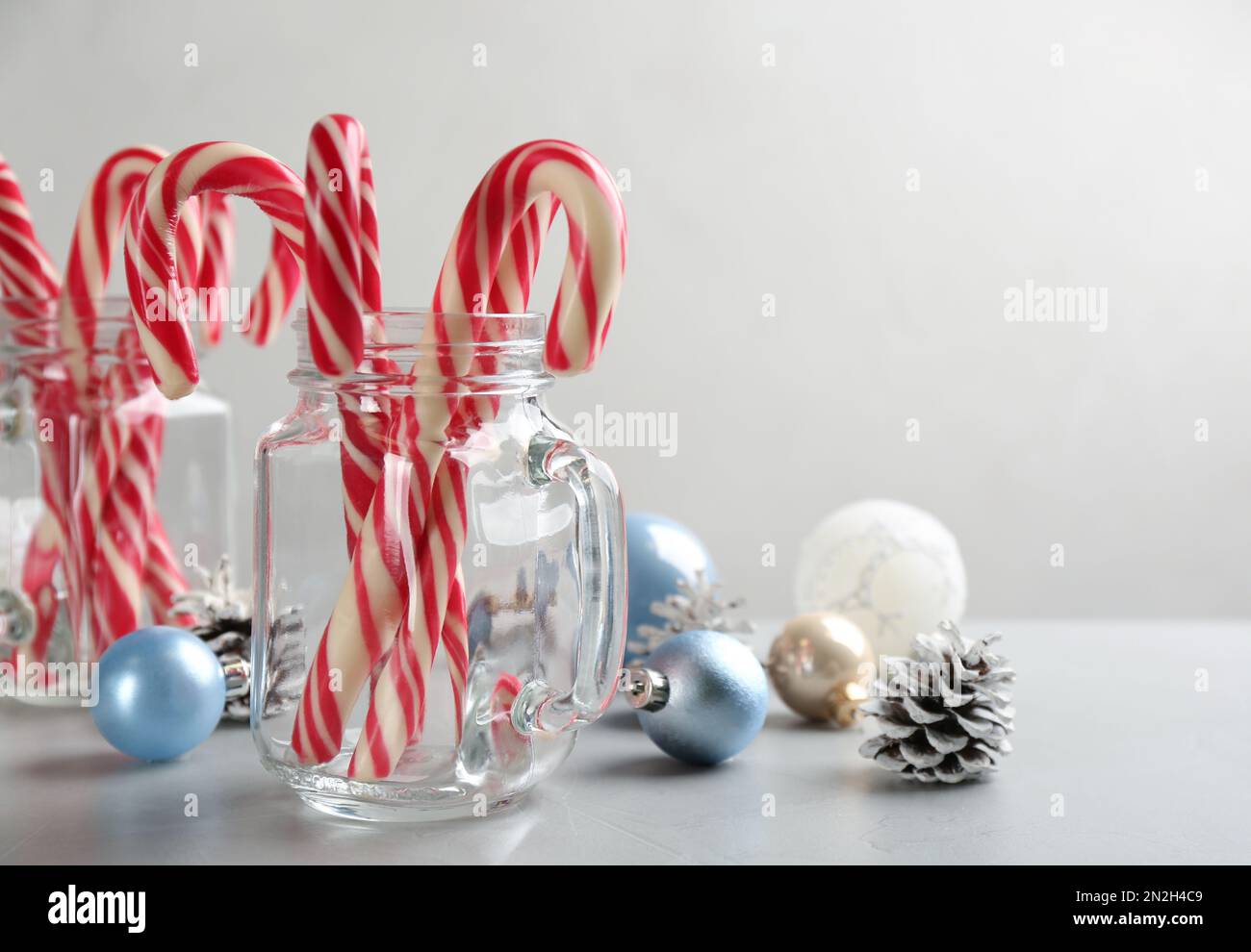 Candy canes and Christmas decor on light grey table, space for text ...