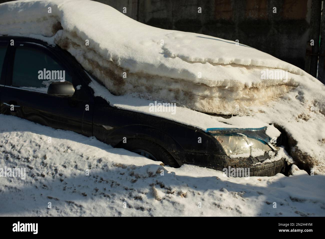 Car under snow. In winter in parking lot. Transport after snowfall ...