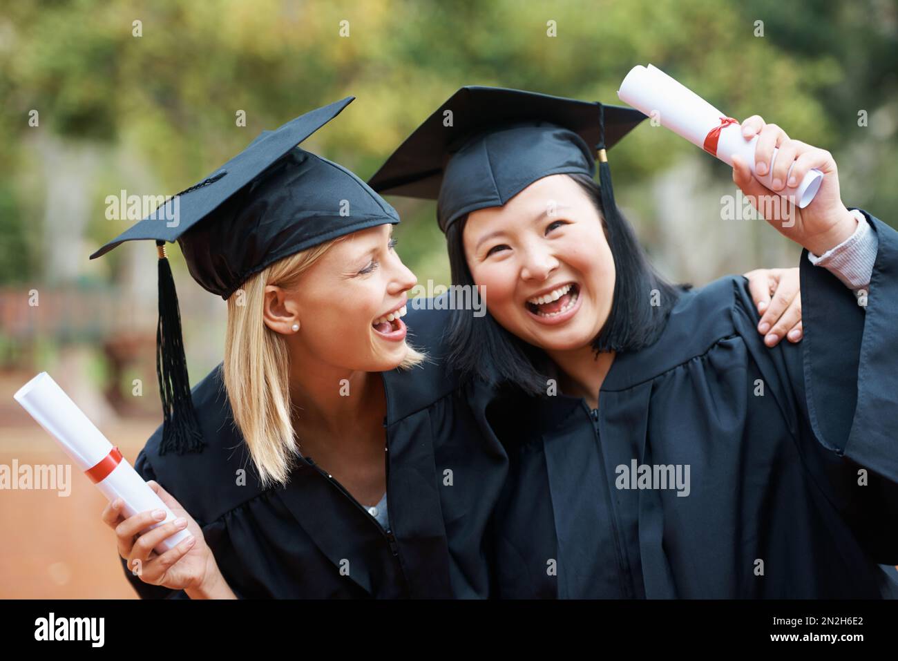 Weve finally graduated. Two friends in togas outside holding up their ...